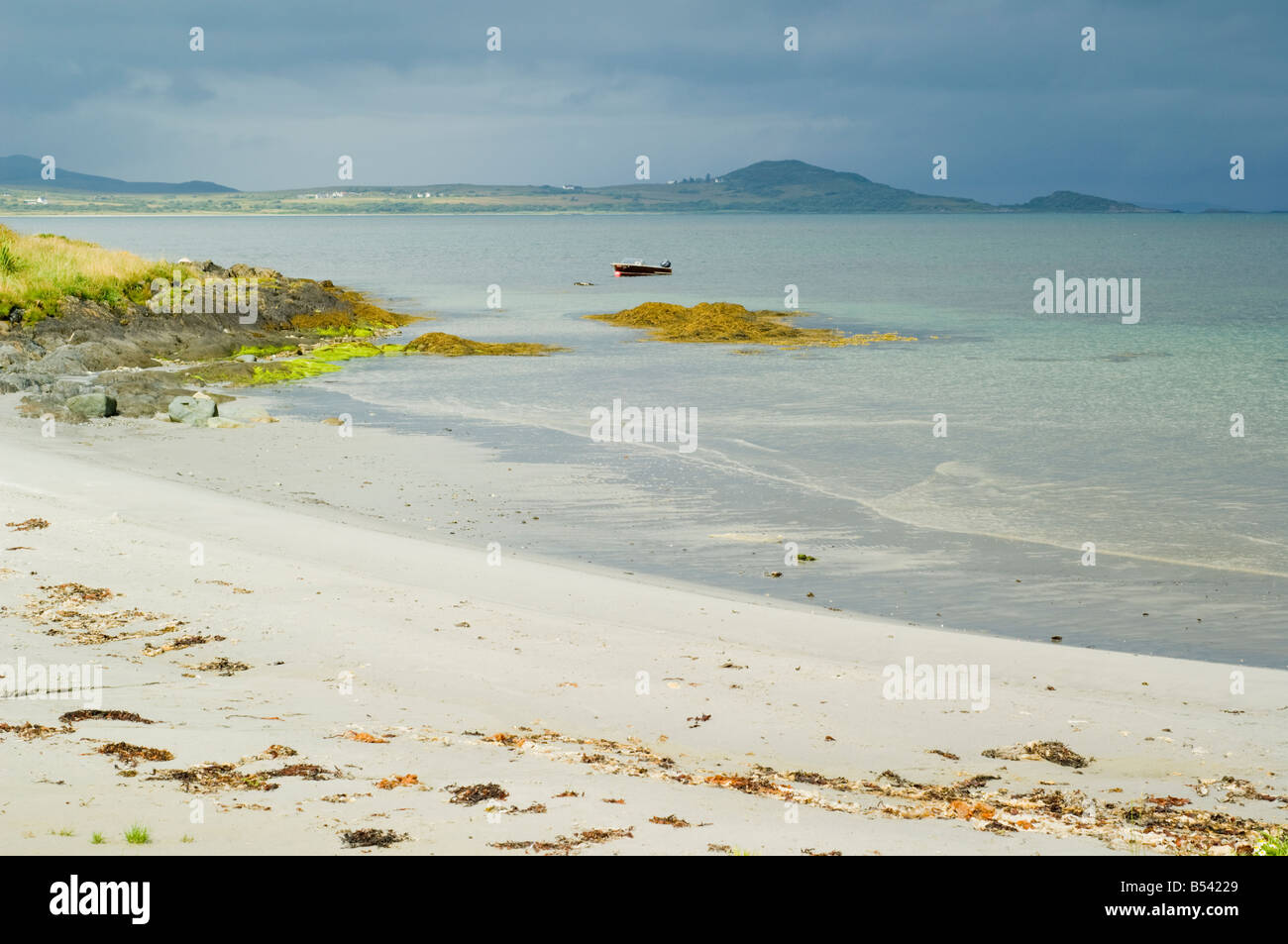 The beach at Craighouse looking across Small Isles Bay to a moored boat ...