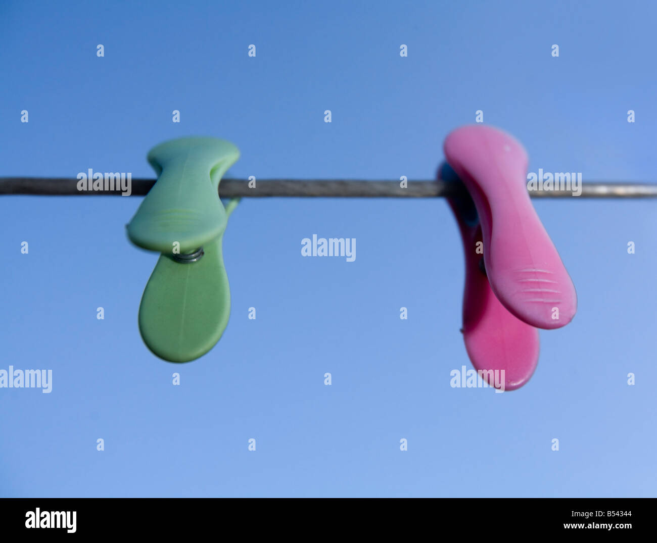 One green and one pink peg on a clothes line Stock Photo - Alamy