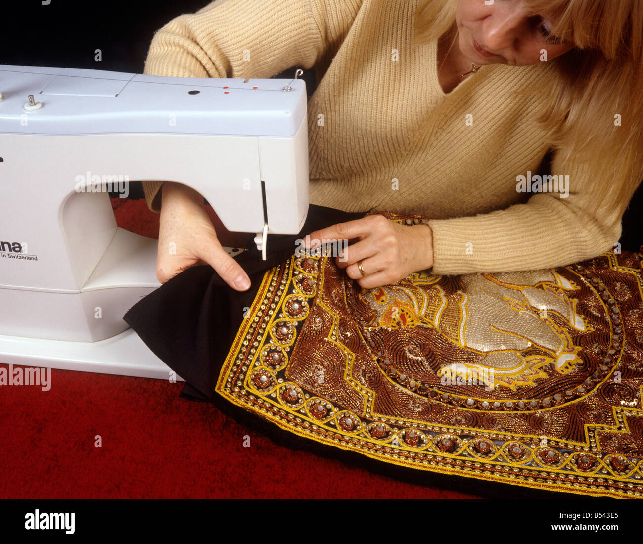 Crafts stretching a Burmese tapestry checking that the sewing is ...