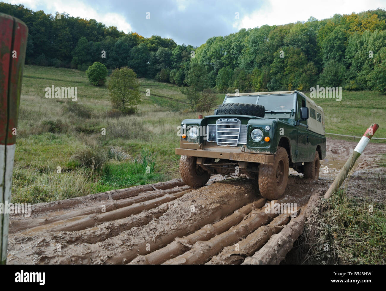 Bronze green 1970s Land Rover Series 3 LWB Soft Top crossing a small ...