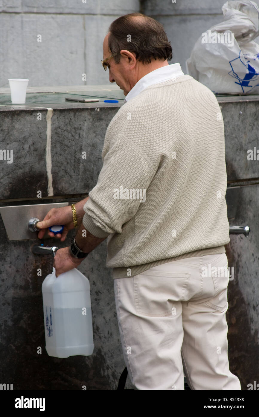 Filling holy water bottles - Lourdes, Southern France Stock Photo - Alamy