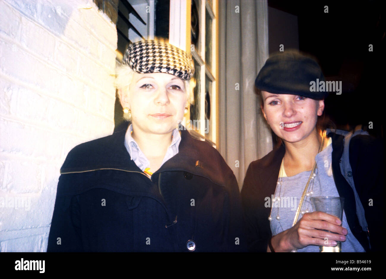 Portrait of two good looking girls, both wearing hats and looking to ...
