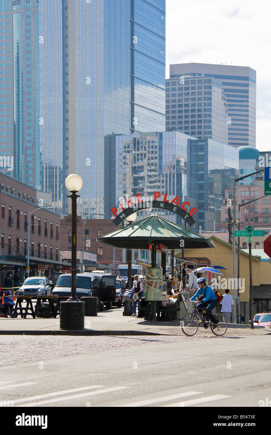 Man on bicycle riding in downtown Seattle Washington under bus stop ...