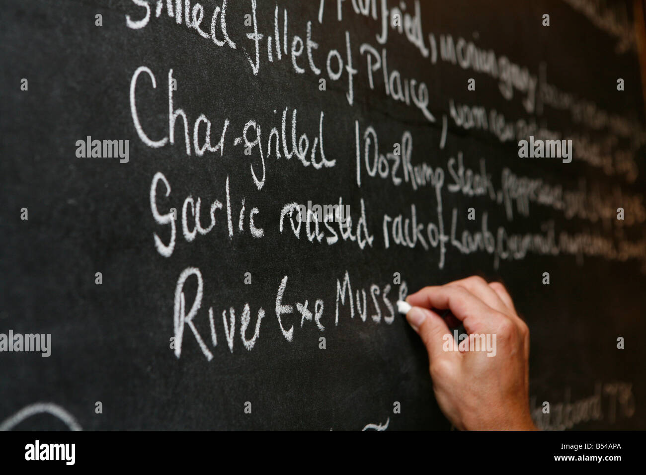 Writing the menu on the blackboard in a pub Stock Photo - Alamy