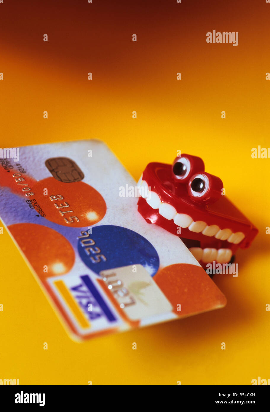credit card in mouth of clockwork teeth Stock Photo - Alamy