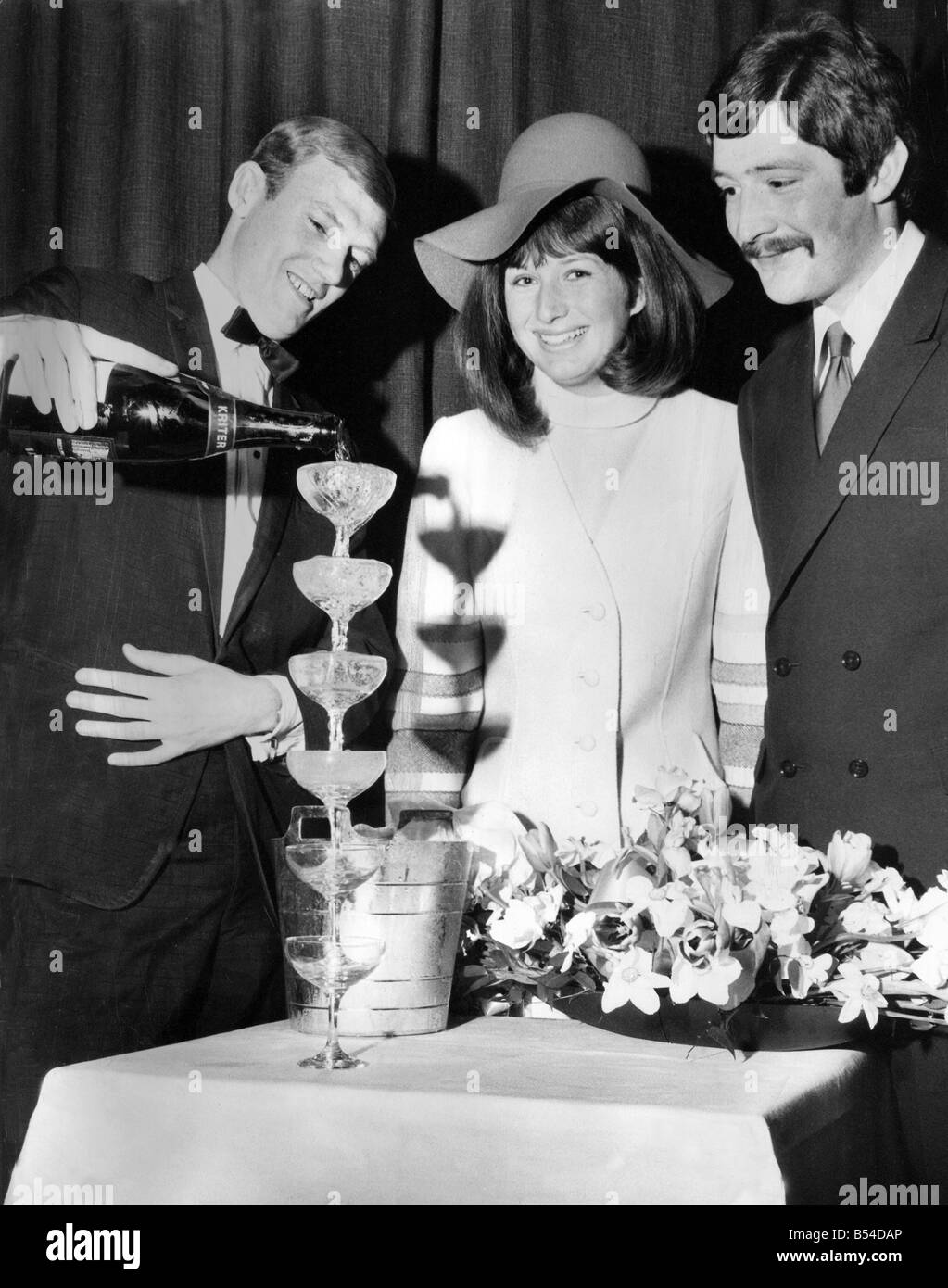 Derek Bower wine waiter at the Moulin Rouge pours six champagne glasses ...