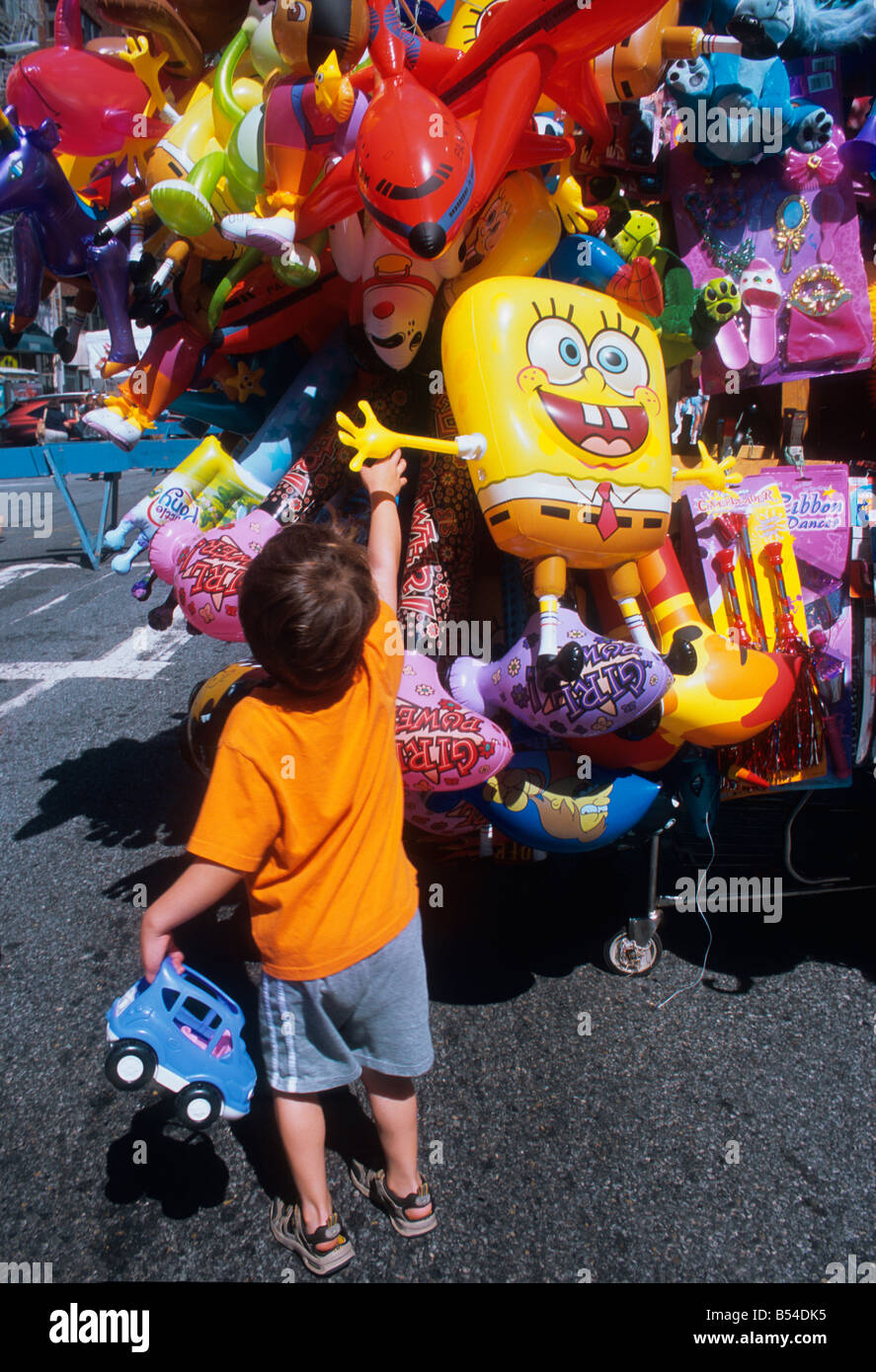 New York child making a choice of a toy balloon at a street fair ...