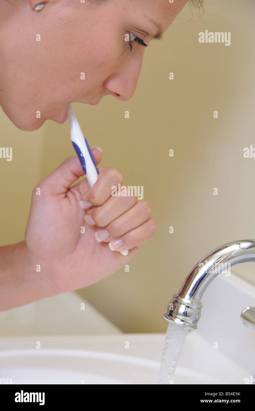 woman brushing teeth with water running Stock Photo - Alamy