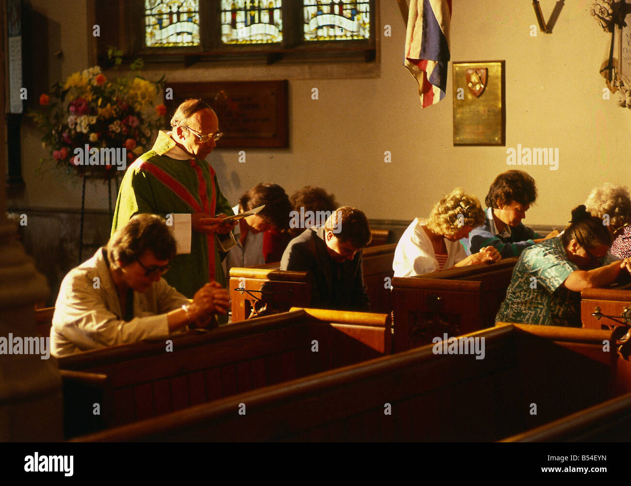 Vicar in church with people praying in Hungerford August 1987 Stock ...