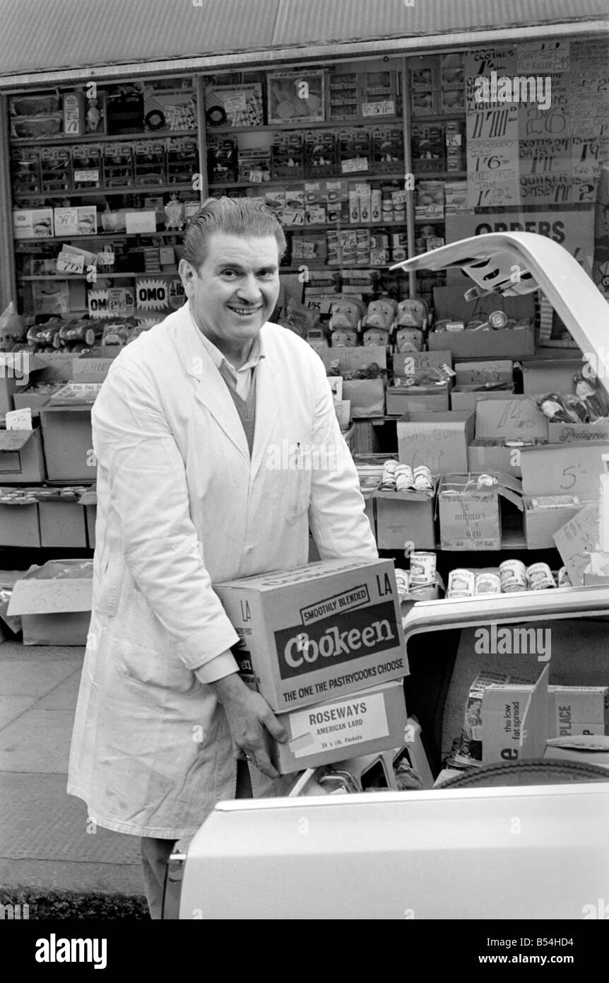 A man loading goods into the boot of his car in his shop at Deptford ...