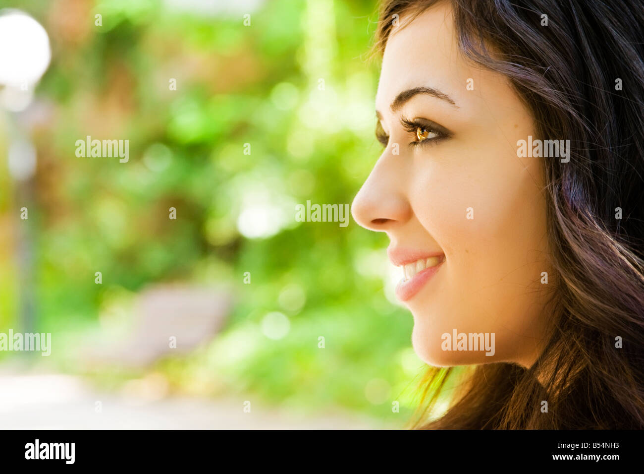 Beautiful woman profile against green background Stock Photo - Alamy