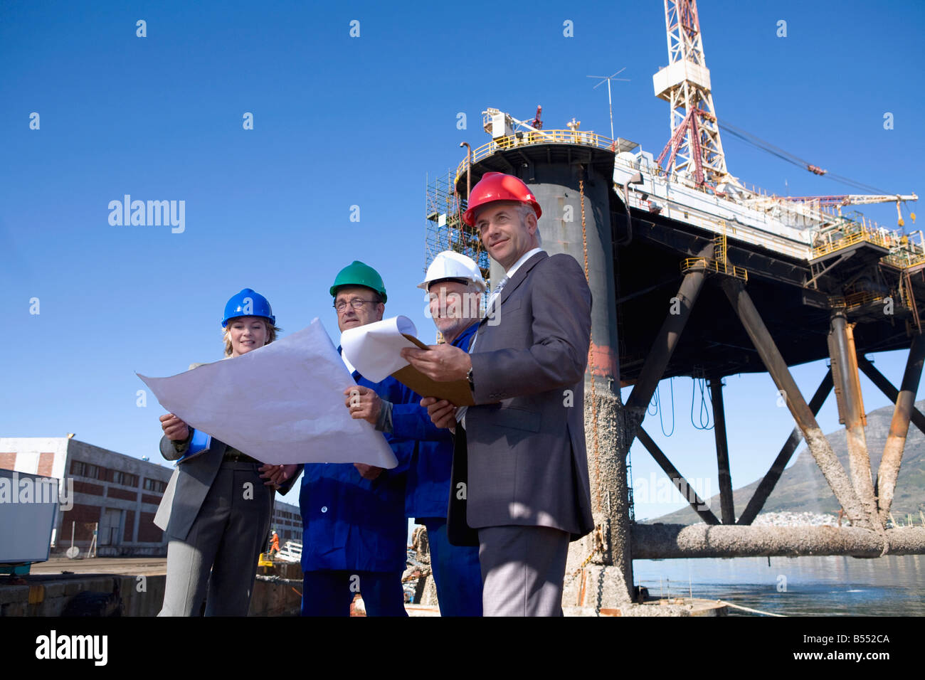 Four construction engineers studying plans Stock Photo - Alamy