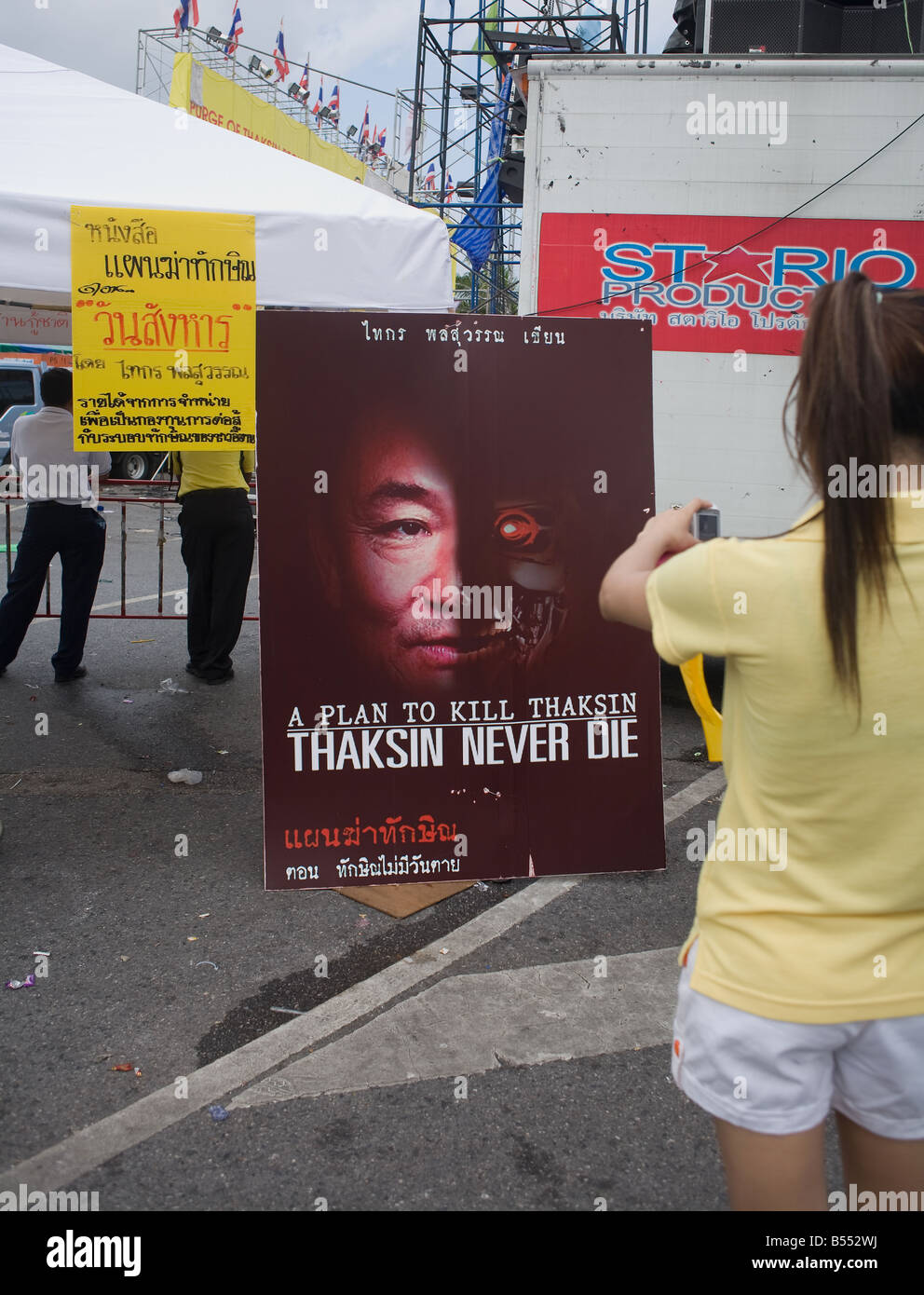 A yellow shirt supporter takes a photograph of a large poster Stock ...