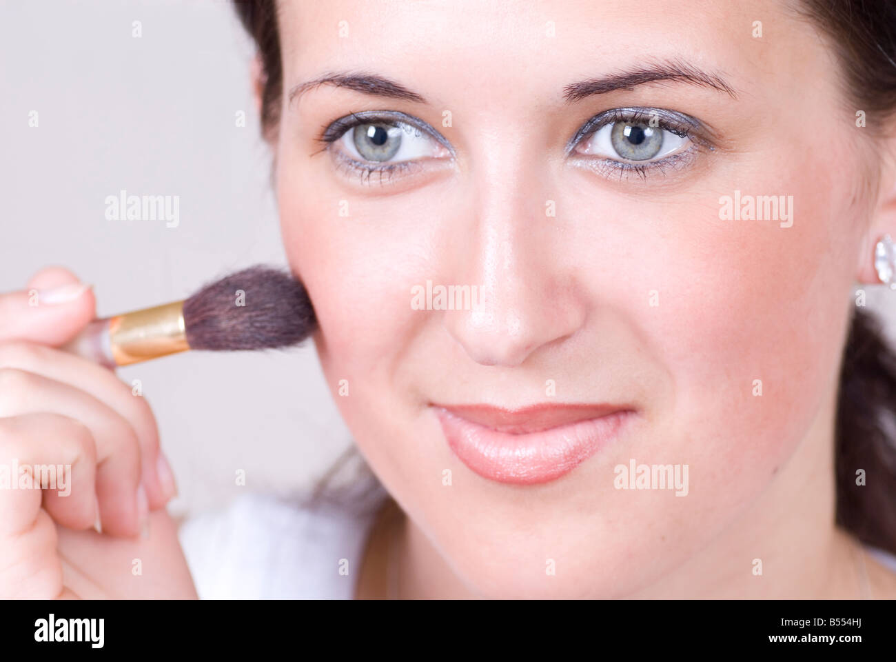 Beautiful woman applying blusher Stock Photo - Alamy