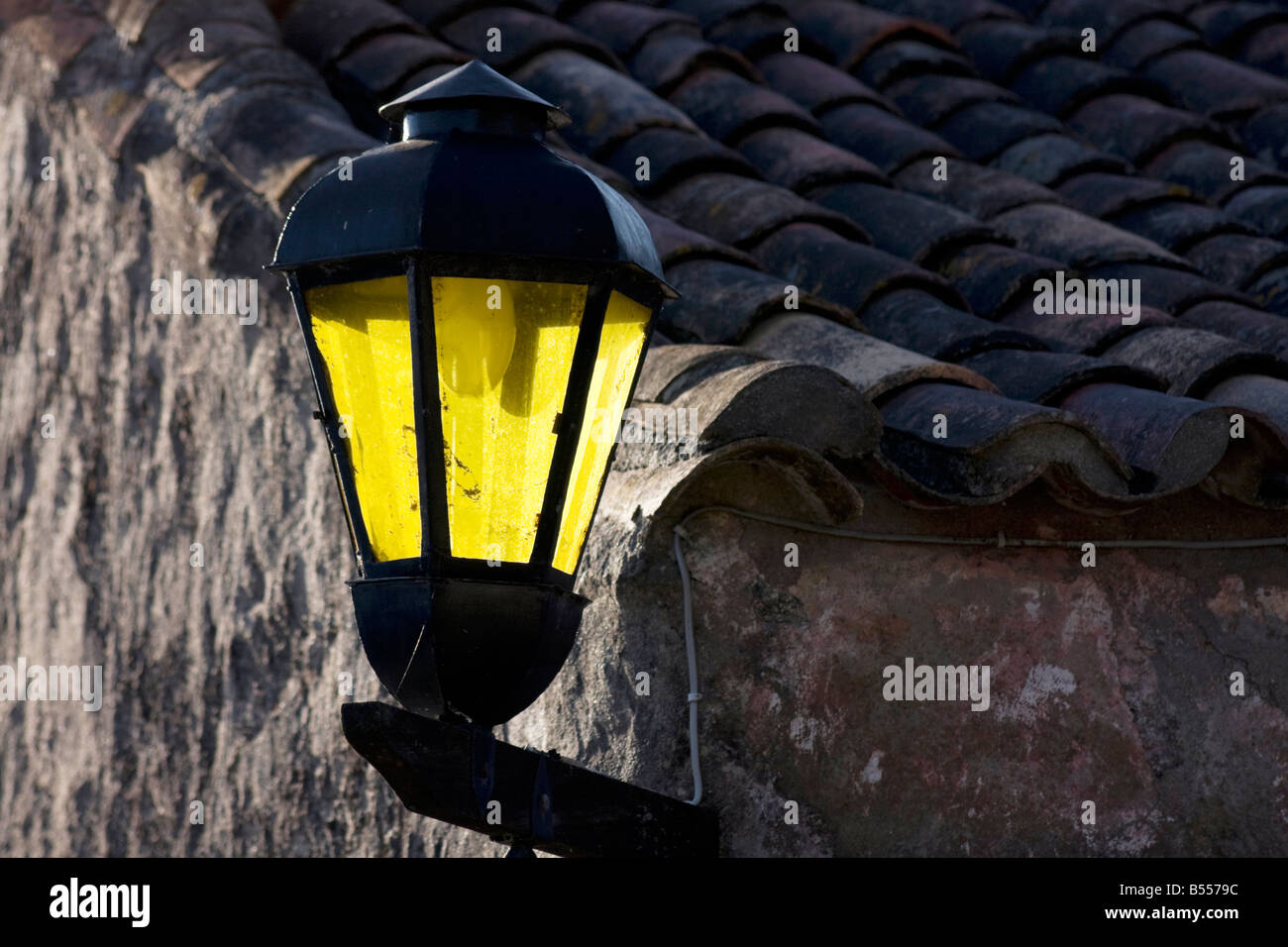 An old fashioned lamp backlit by the sun in the Calle de Los Suspiros ...