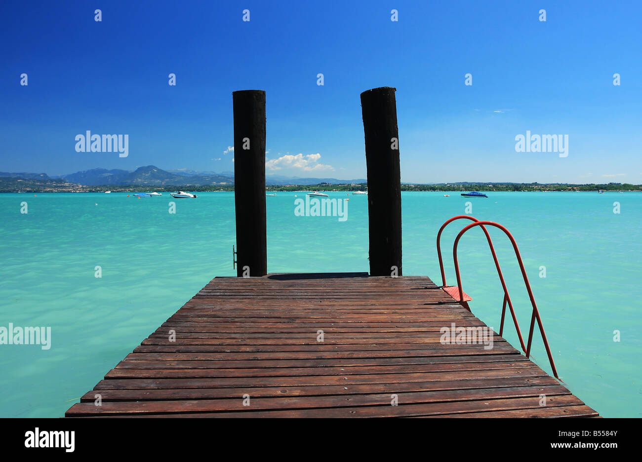 a small jetty in lake Garda Italy fantastic color in the water and sky ...