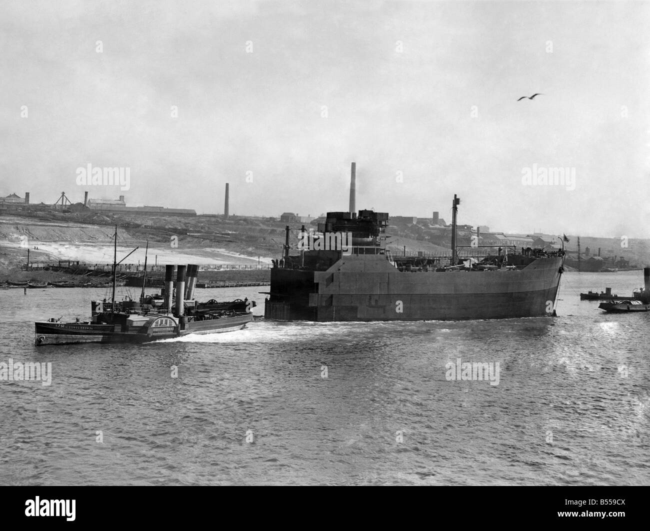 World War II Shipbuilding. Tugs pull The bow Section of a new cargo ...