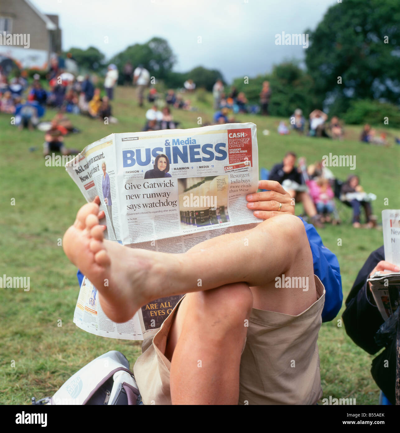 A man reading the Business and Media section of the Sunday Observer ...