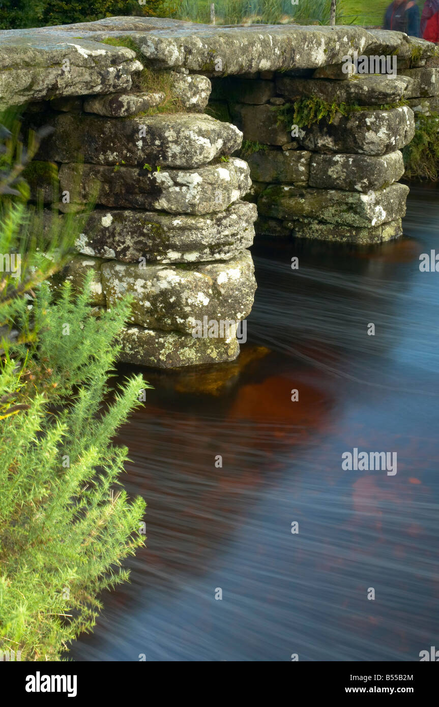 The River Dart flowing under a stone clapper bridge on Dartmoor Devon ...