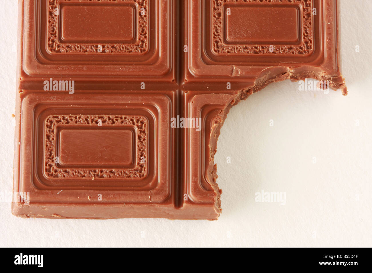 Milk chocolate isolated on white with a bite taken out of it shot in ...