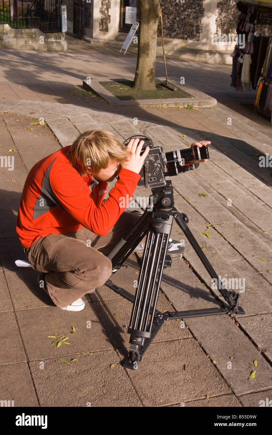 Young man using movie camera on large heavy duty tripod in Norwich ...