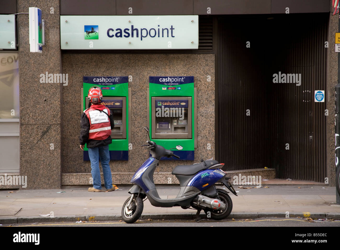 Courier at cash machine Stock Photo - Alamy