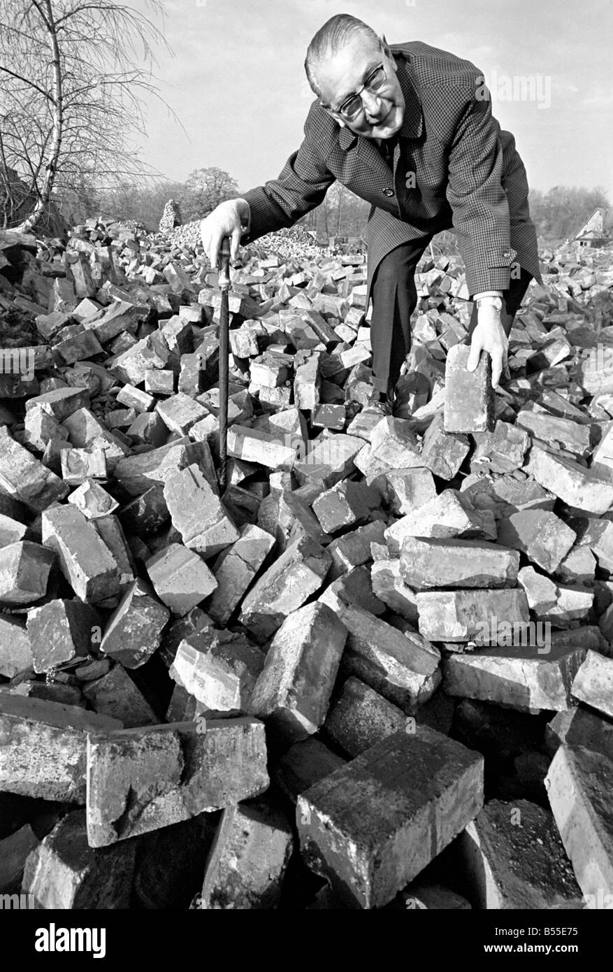People - elderly. An old man searching through a pile of bricks ...