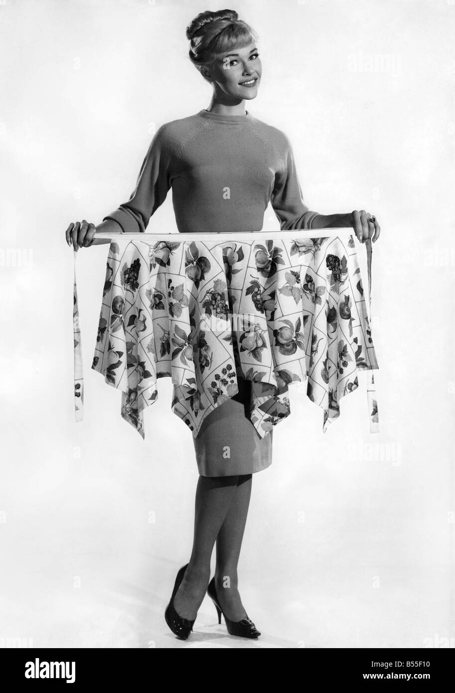 Model Jo Waring holding up a floral skirt. December 1961 P008815 Stock ...