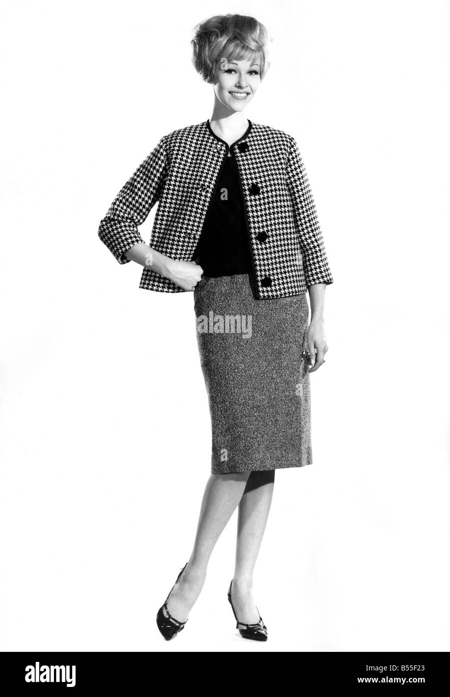 Model Jo Waring wearing skirt with jacket and top, standing with hands ...