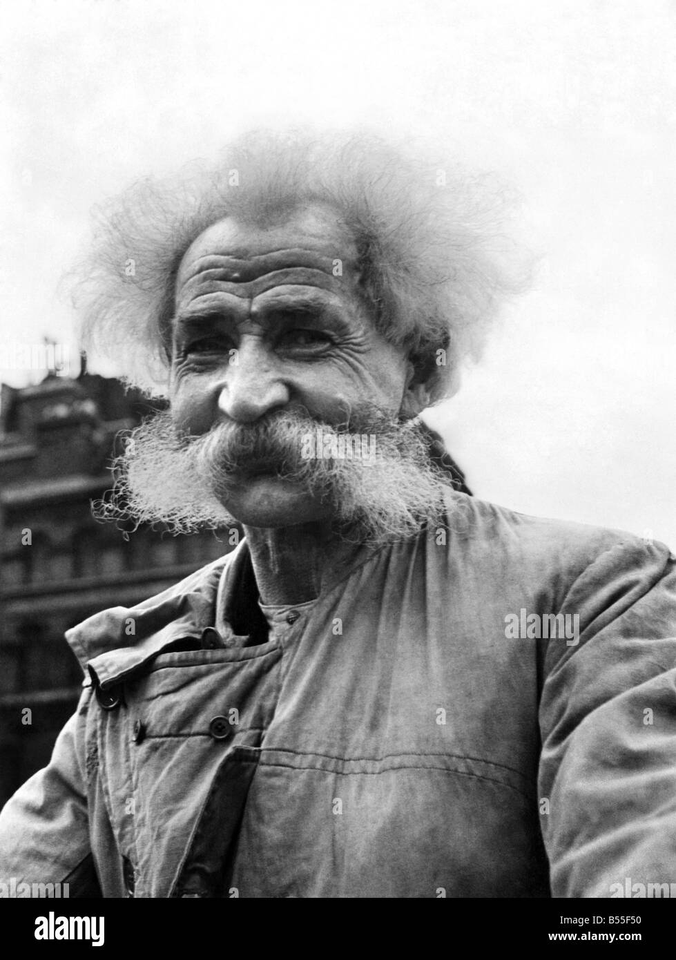 An eldelry man with with white fuzzy hair and matching beard, smiles ...