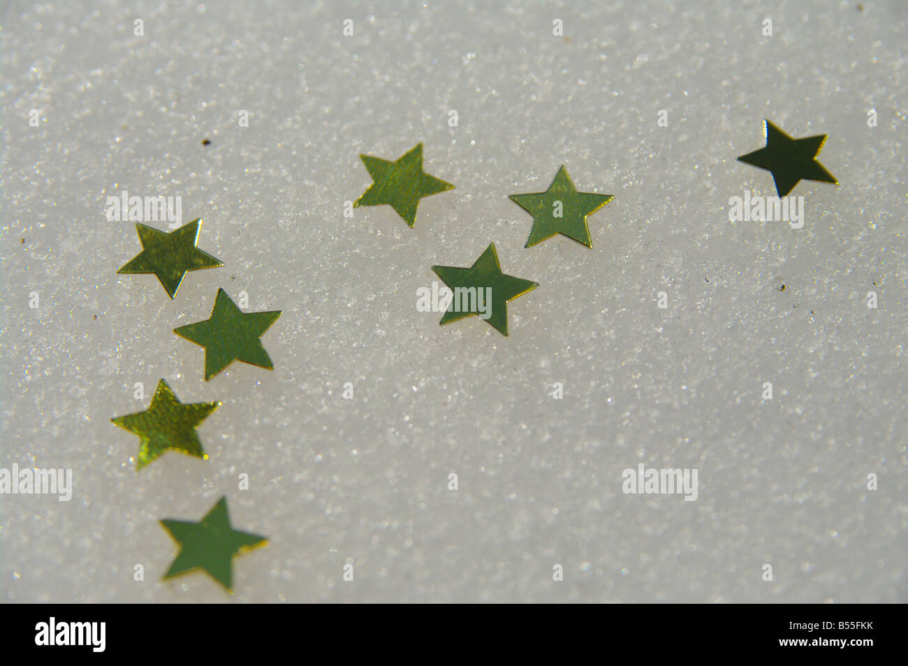 golden snow stars on a real snowy icy surface Stock Photo - Alamy