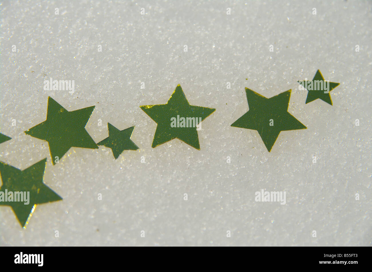 golden snow stars on a real snowy icy surface Stock Photo - Alamy