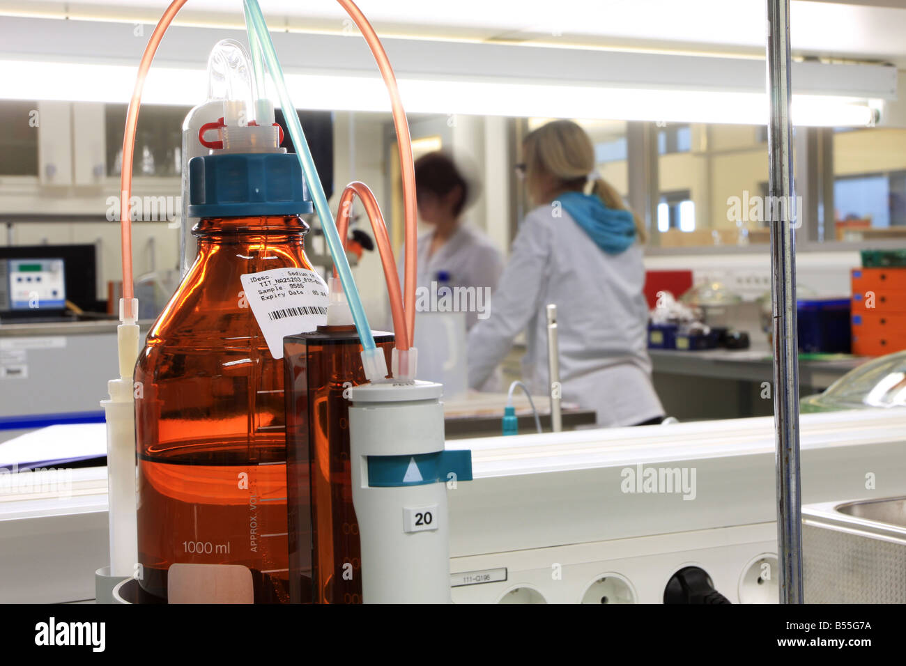 test tubes and substances in a real laboratory scientists in background ...