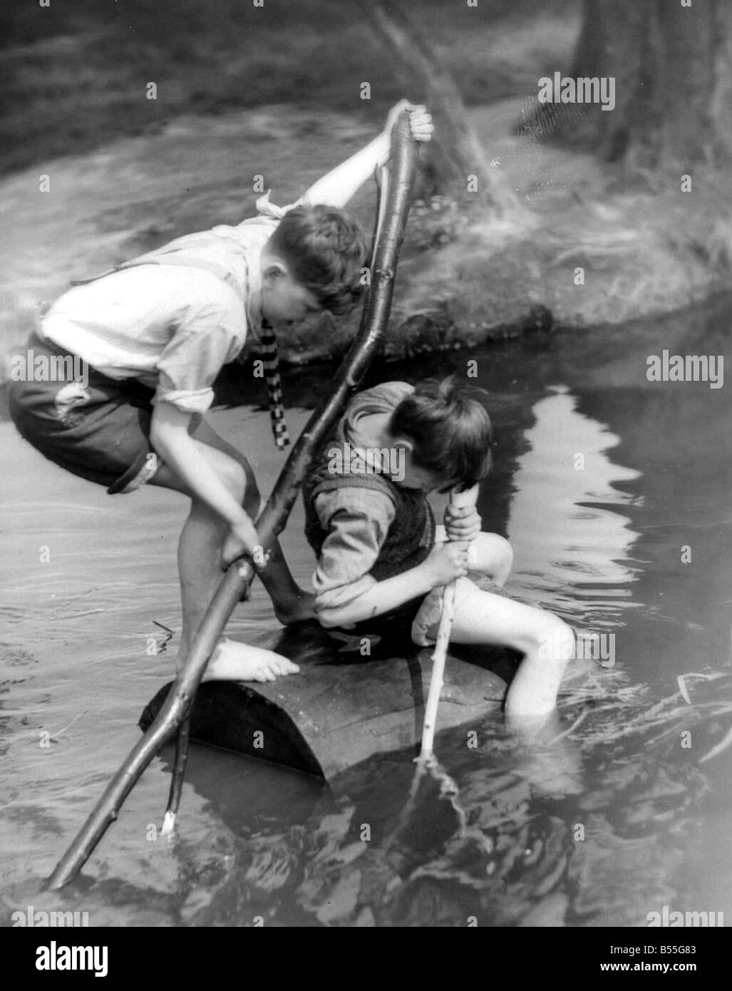 Young boys using large log as a raft. c.1945 P044494 Stock Photo - Alamy