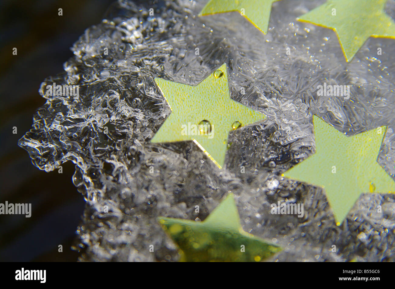 golden snow stars on a real snowy icy surface Stock Photo - Alamy