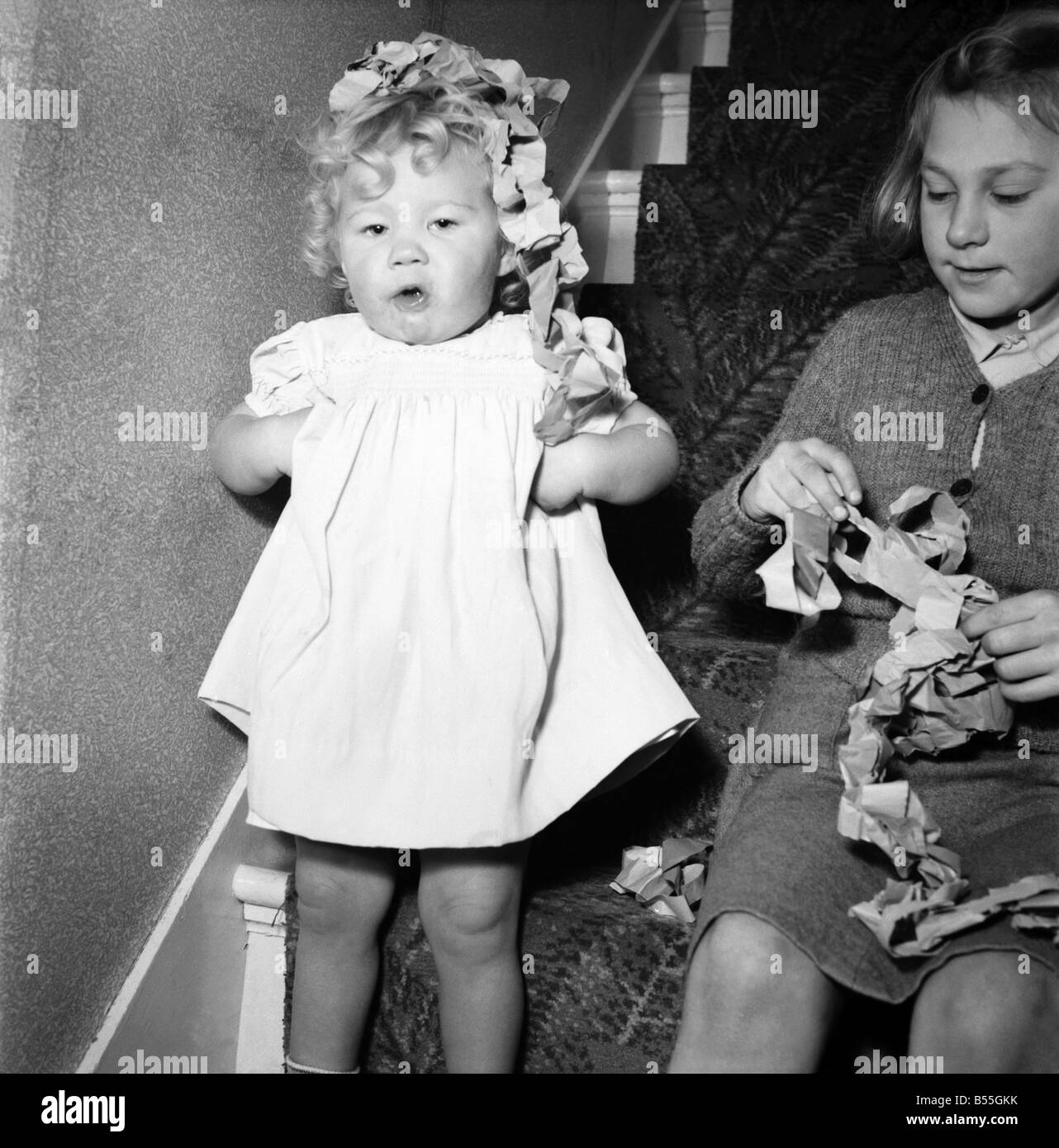 15 month-old Janice Cook with Christmas chains playing in the living ...