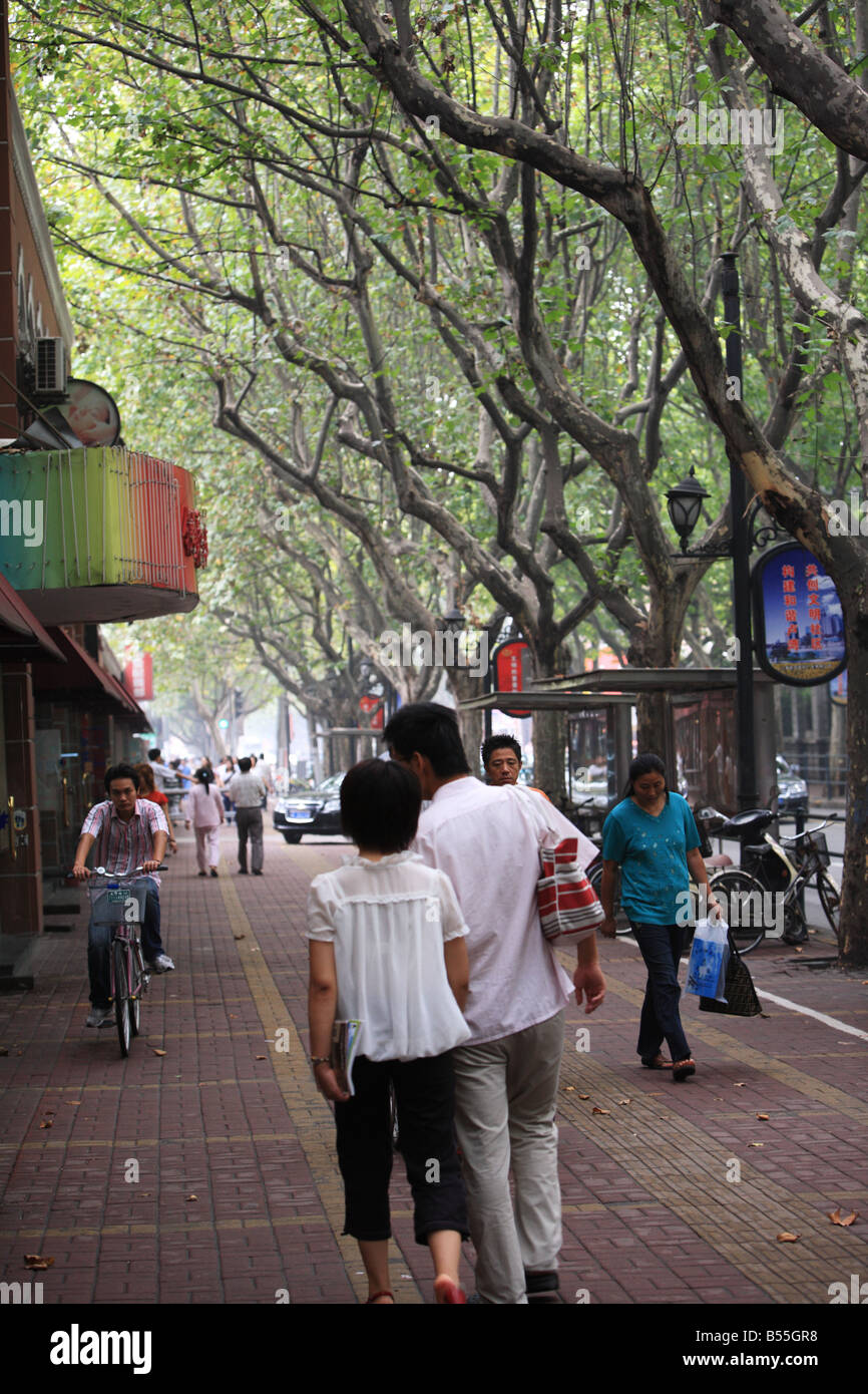 Pedestrians walking along the tree lined streets of the French ...