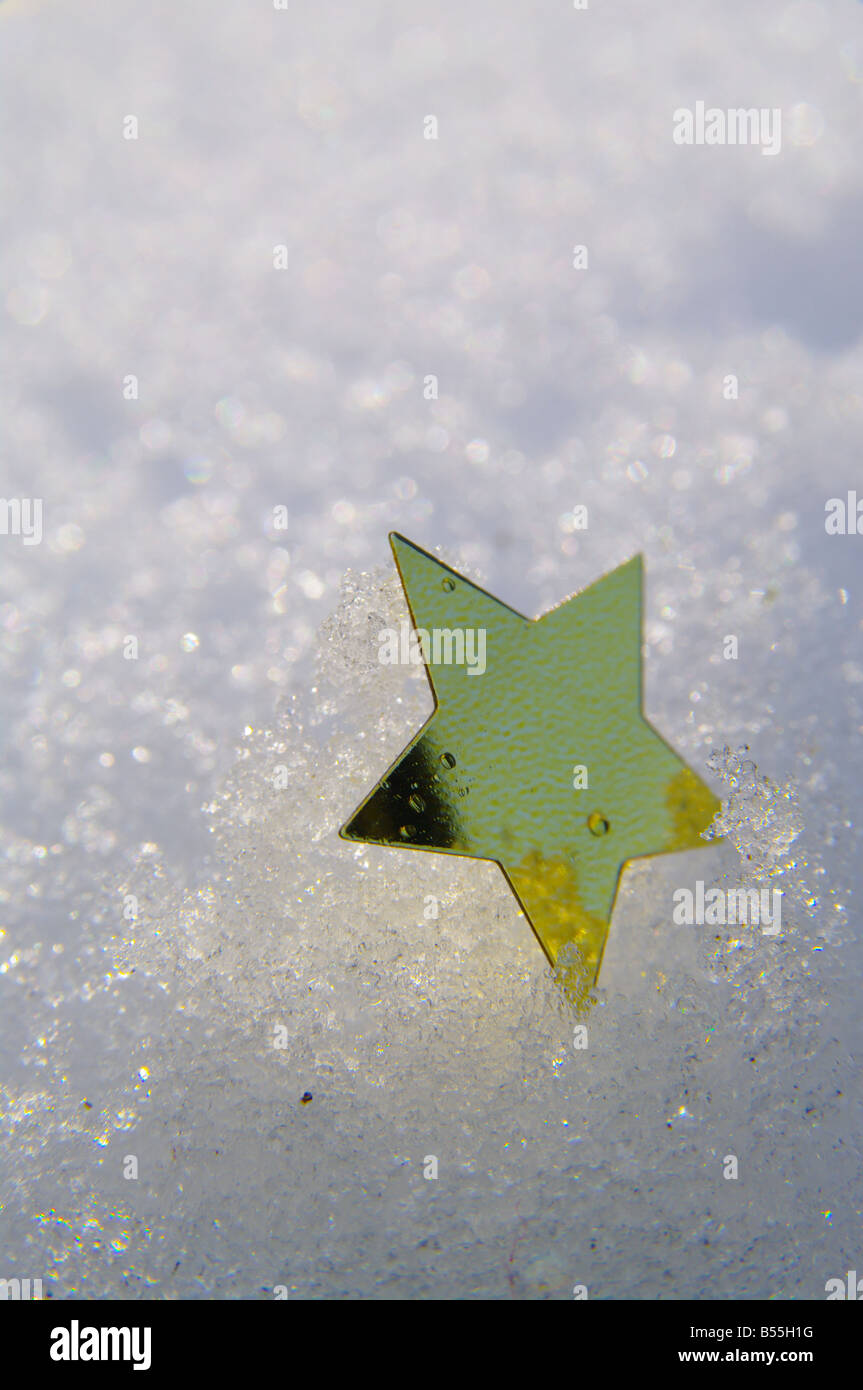 golden snow stars on a real snowy icy surface Stock Photo - Alamy