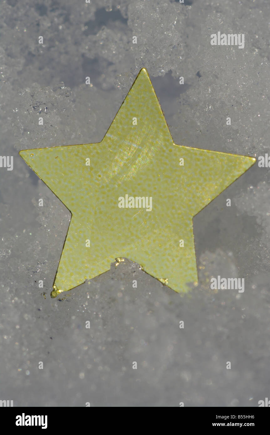 golden snow stars on a real snowy icy surface Stock Photo - Alamy