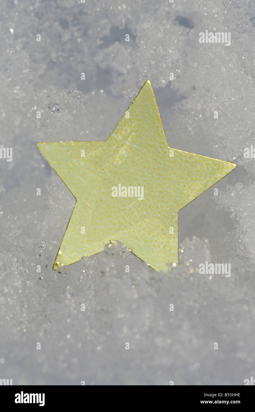golden snow stars on a real snowy icy surface Stock Photo - Alamy