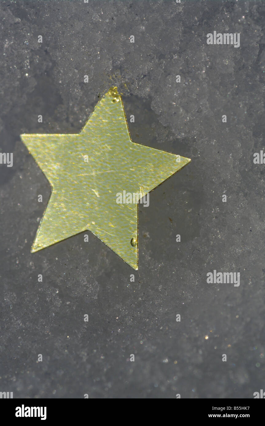 golden snow stars on a real snowy icy surface Stock Photo - Alamy