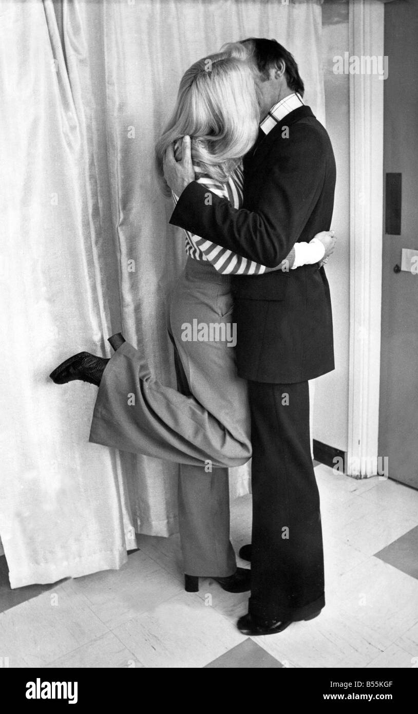 A young couple enjoy a kiss and cuddle Stock Photo - Alamy