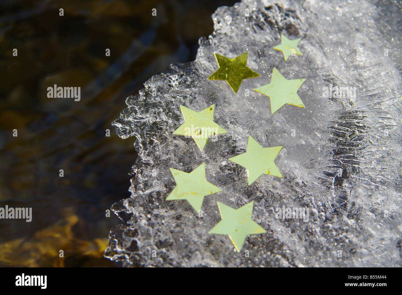 golden snow stars on a real snowy icy surface Stock Photo - Alamy