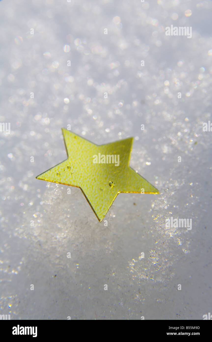 golden snow stars on a real snowy icy surface Stock Photo - Alamy