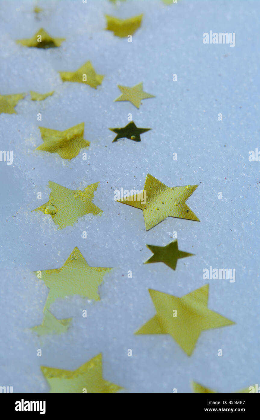golden snow stars on a real snowy icy surface Stock Photo - Alamy