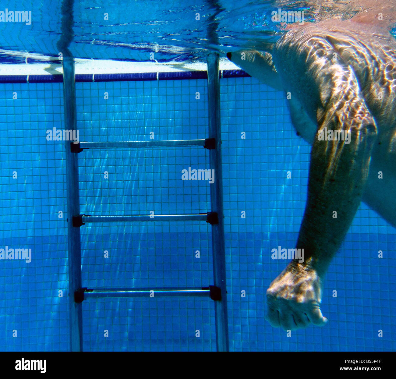 man swimming near pool exit ladder Stock Photo - Alamy