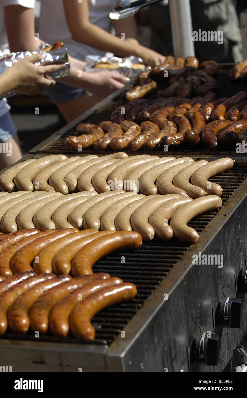 Sausages Hot Dogs and Wieners being grilled on a large outdoor barbecue ...