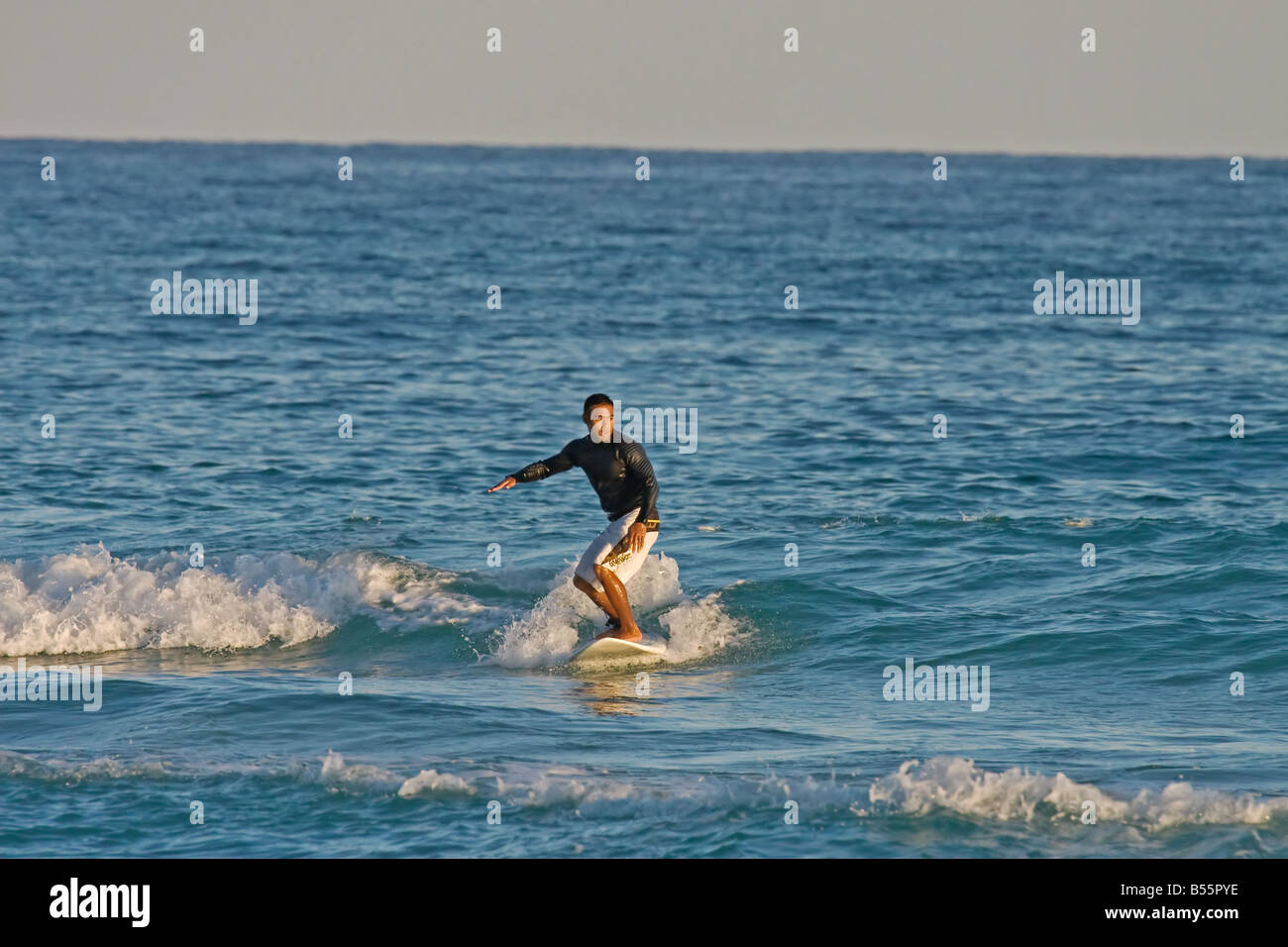 Young man surfing the blue water Stock Photo - Alamy