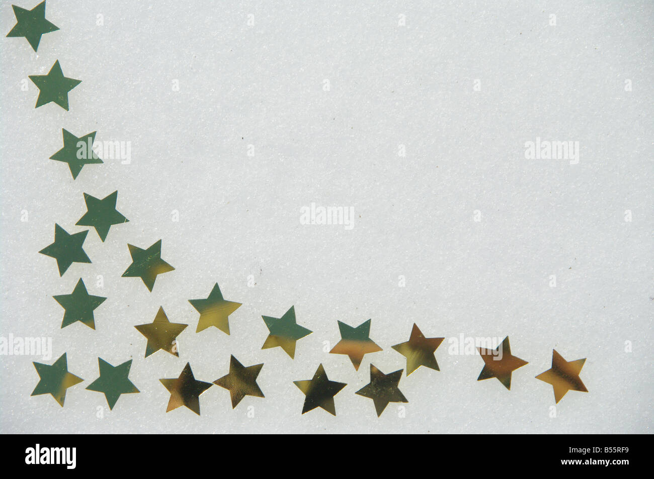golden snow stars on a real snowy icy surface Stock Photo - Alamy