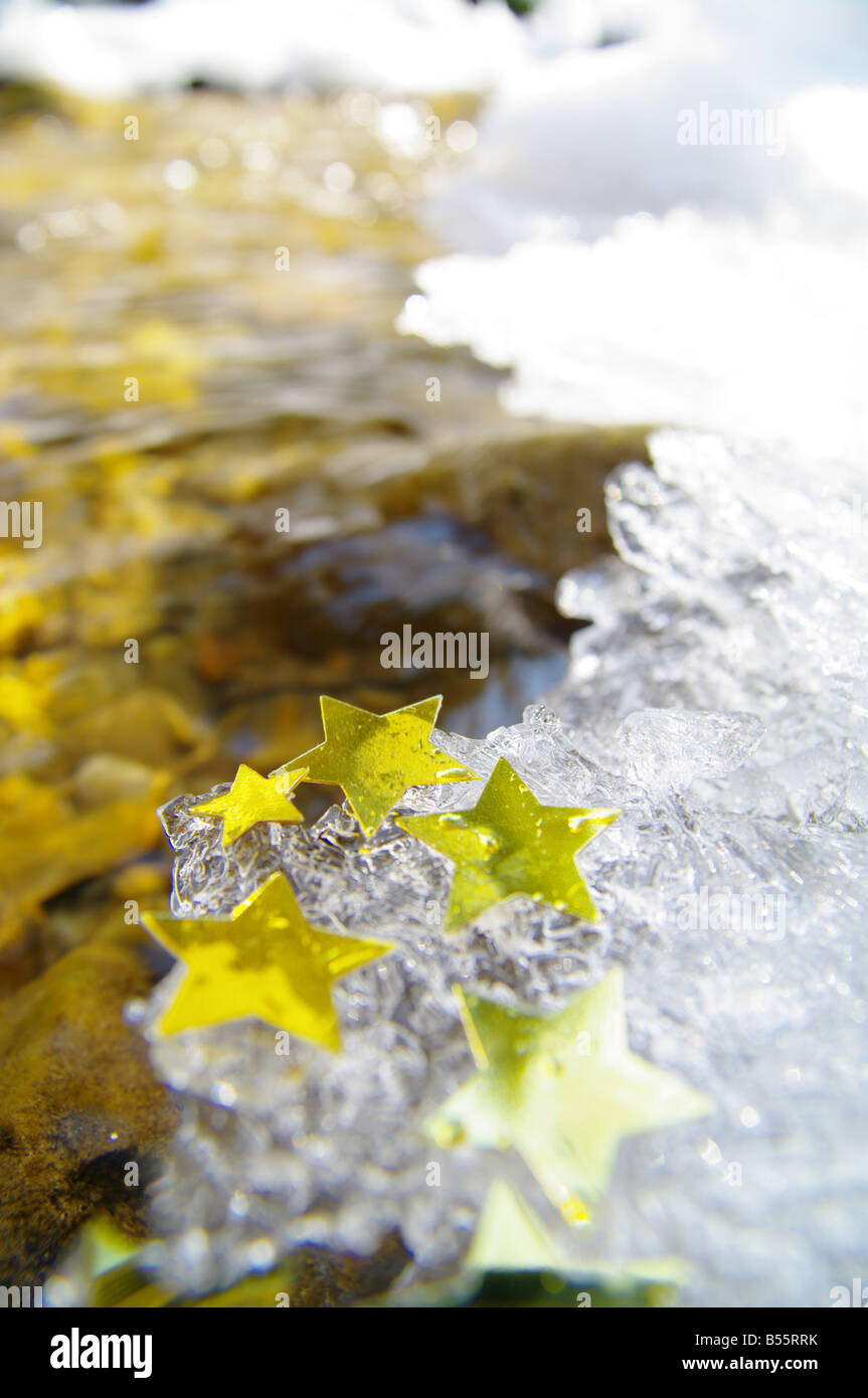 golden snow stars on a real snowy icy surface Stock Photo - Alamy